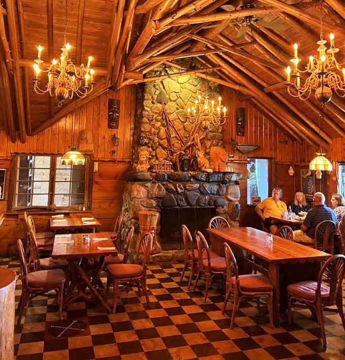 Chandeliers illuminate handcrafted wooden furniture in a space that feels like dining inside folk art itself.
