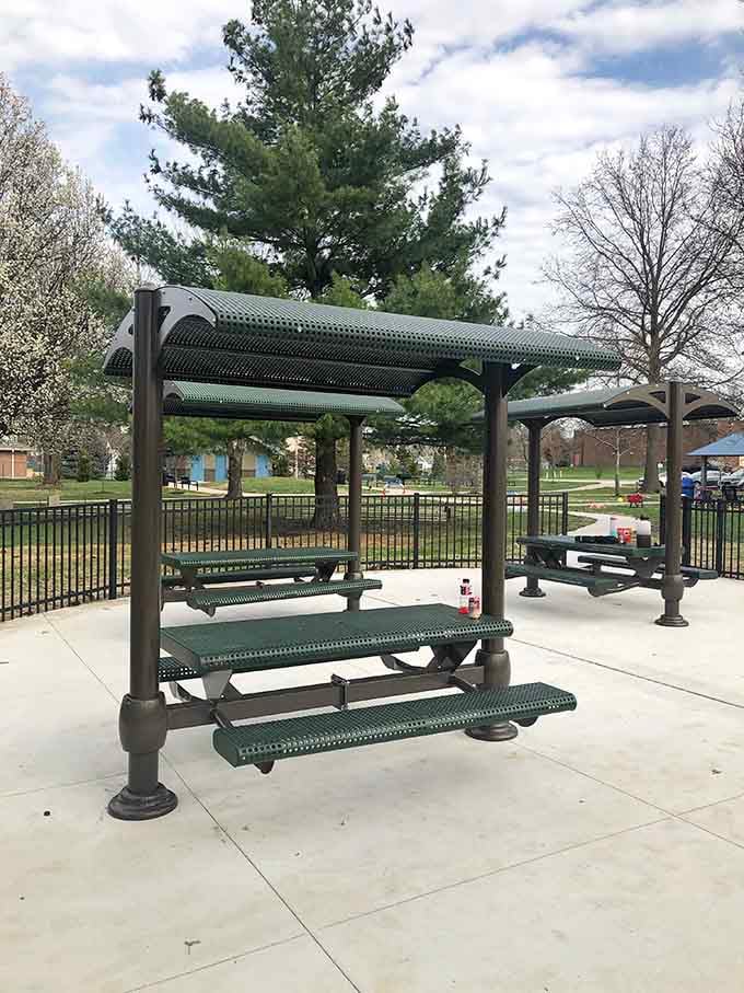 Shaded picnic tables mean parents can actually sit down while keeping eyes on their little adventurers across the playground.