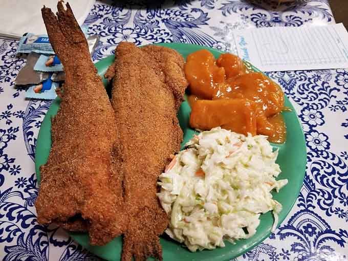 Whole fried catfish with candied yams and coleslaw. Southern seafood done right in Alabama's capital city.