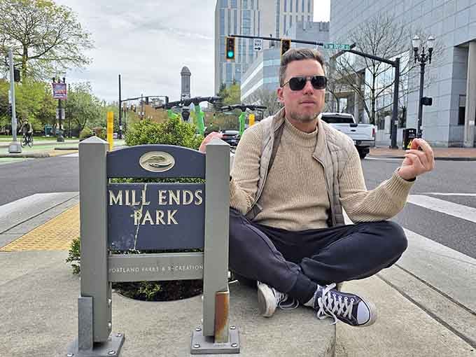 This visitor demonstrates the park's scale perfectly, sitting cross-legged beside a green space that's genuinely smaller than most throw rugs.