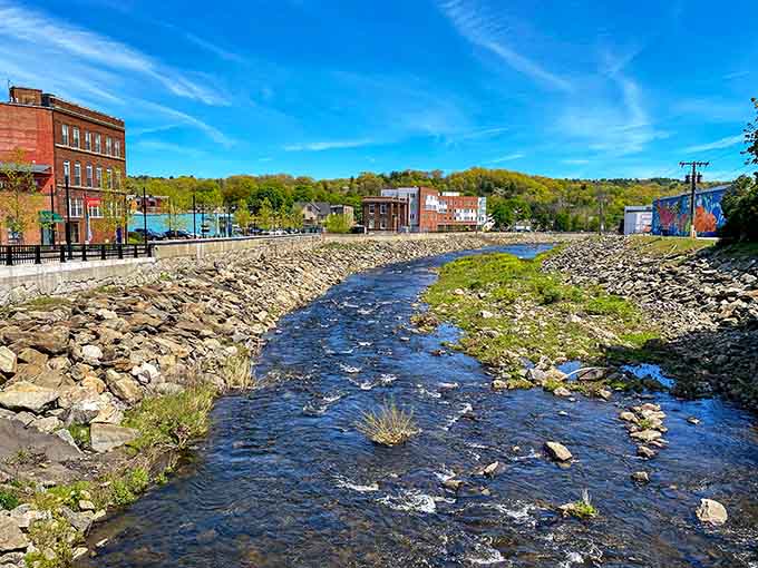 The Naugatuck River flows past historic brick buildings, connecting past and present like a liquid timeline through the valley.