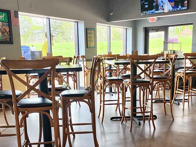 Spacious dining room with TVs and natural light, perfect for watching the game while demolishing some ribs.