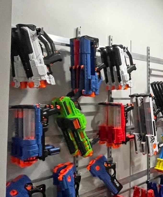 An impressive collection of Nerf hardware hangs ready for action, from compact pistols to elaborate rifles that mean serious foam business.