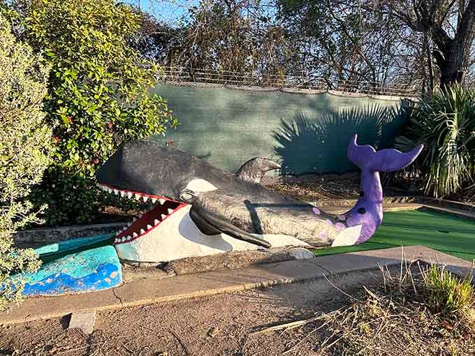 The whale's mouth is wide open in permanent surprise, probably shocked at how many golf balls have missed that hole.