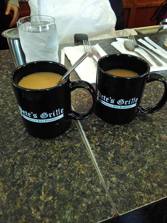 Coffee mugs bearing the Pete's Grille name, filled with liquid motivation that doesn't require a mortgage.