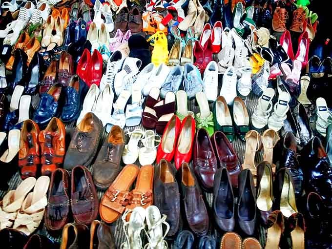 A rainbow of footwear cascades down the wall, from sensible flats to statement heels that once strutted their stuff.