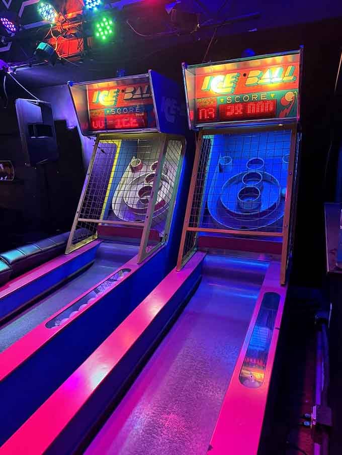 Classic skee-ball lanes glow under neon lights, ready to settle debates about who's got the steadiest hand.