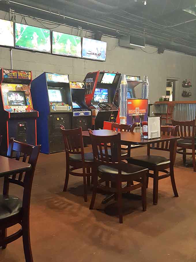 Classic arcade cabinets and wooden tables create a space where nostalgia meets cold beer and nobody judges your high score attempts.