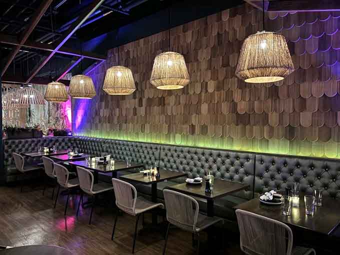 Booth seating under woven lamps where every meal feels like dining in a sophisticated tropical dream sequence.