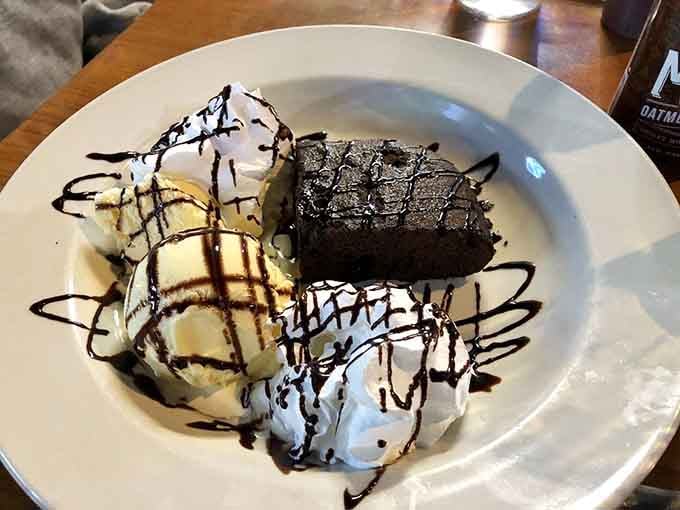 Chocolate brownie sundae drizzled with sauce, proving that dessert after barbecue is always a good decision.