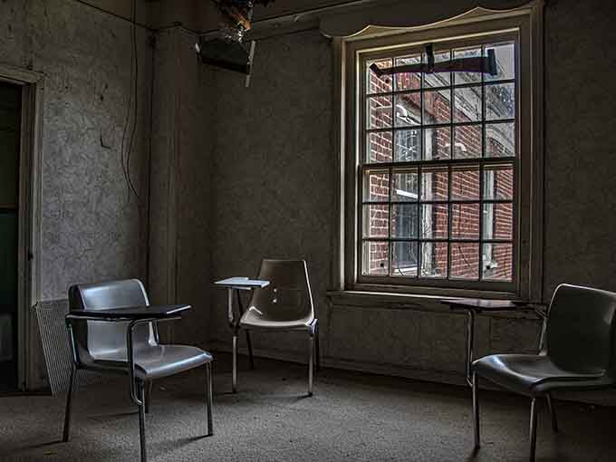 Student chairs arranged around a window, forever waiting for a class that will never meet again in this space.