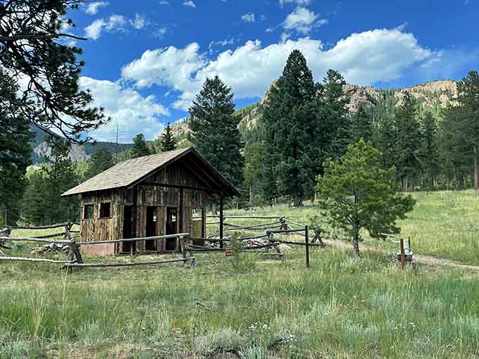 An old barn stands against mountain backdrops, proving that some things just get better with age and altitude.