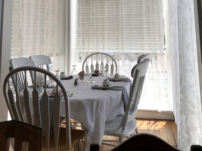 Sunlight streams through lace curtains onto tables set for guests who deserve something special today.