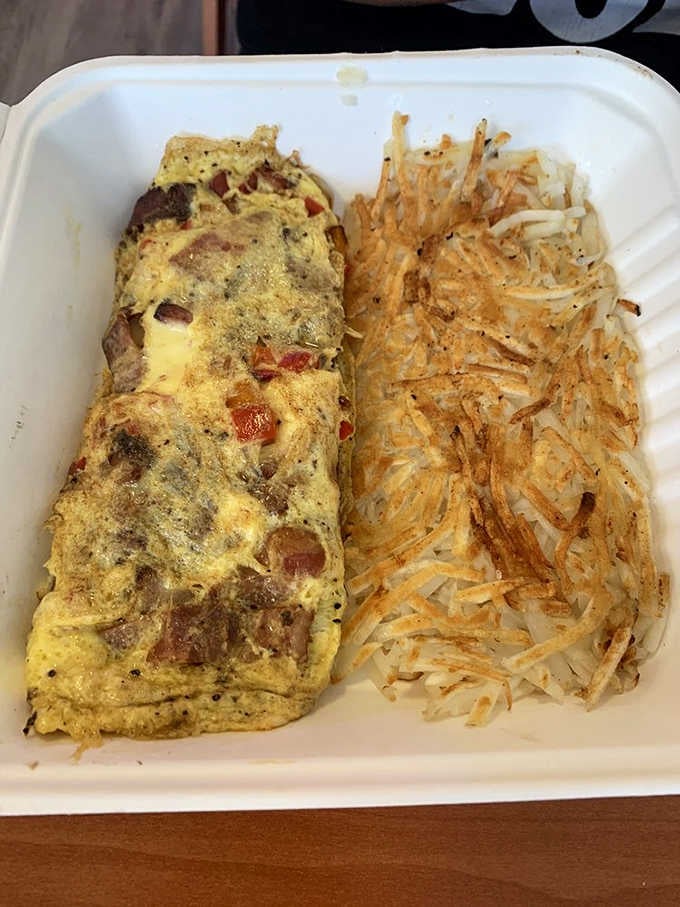 A fluffy omelet packed with bacon and peppers alongside golden hash browns, breakfast done exactly right every single time.