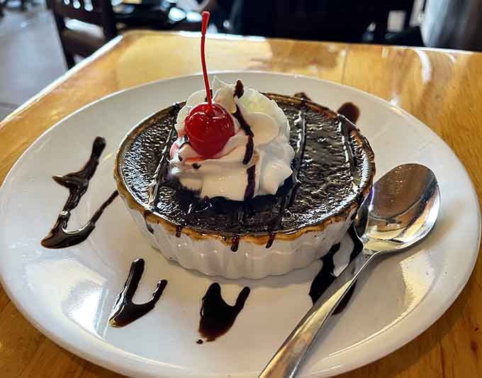 Cr&egrave;me br&ucirc;l&eacute;e topped with a cherry and whipped cream, because sometimes dessert needs to be fancy and fun at the same time.