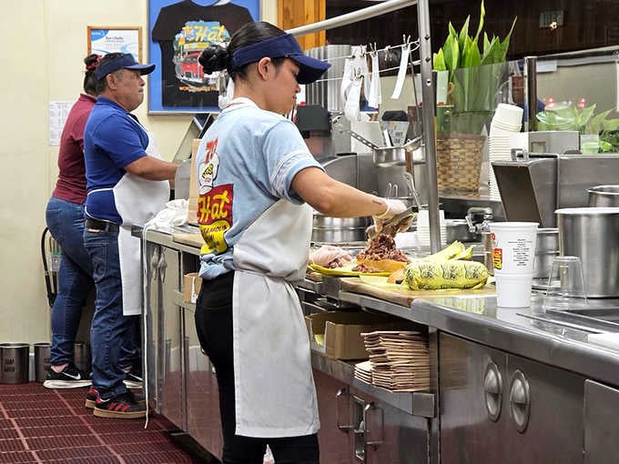 Behind the counter, skilled hands work with practiced efficiency, building sandwiches like edible skyscrapers all day.