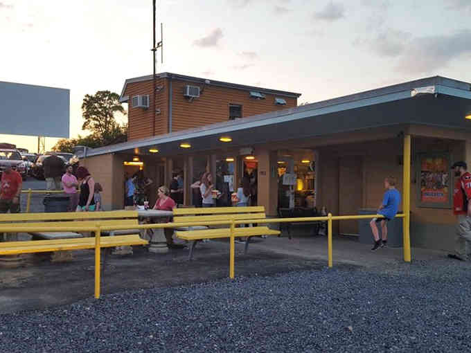 Yellow picnic tables and hungry moviegoers, the concession stand is where the real pre-show action happens.