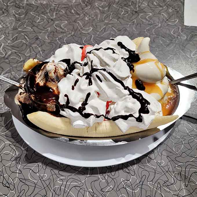 This towering banana split with whipped cream and drizzles looks like happiness served in a bowl.