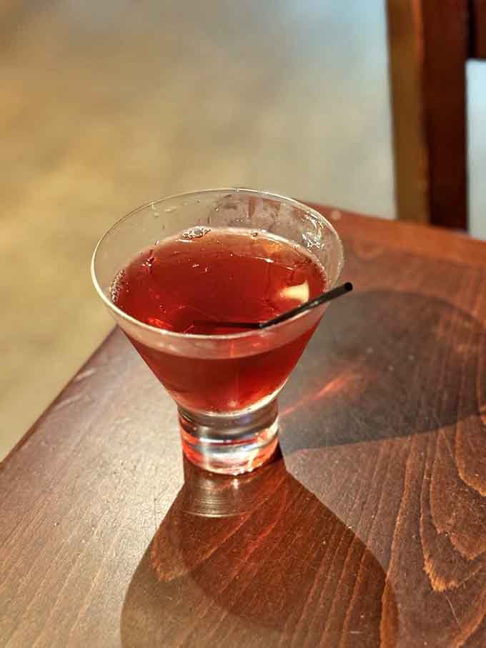 A perfectly crafted Manhattan in a martini glass is the kind of sophistication that pairs surprisingly well with coffin chandeliers.