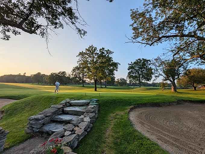 Golden hour on the green, where that lone golfer has found either inner peace or a really tricky putt.
