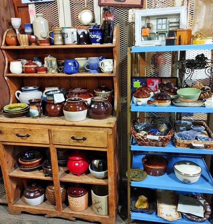 Shelves overflow with colorful vintage crocks, bowls, and pottery that could transform any kitchen into a charming, eclectic cooking space today.
