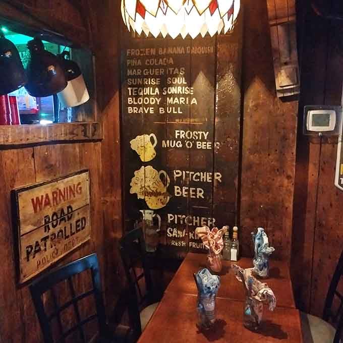 Hand-painted drink menus on weathered wood panels, where even the décor has more personality than most restaurants' entire concept.