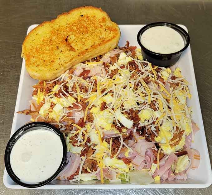 That chef salad is piled so high with ham, cheese, and bacon, it's practically a deli counter explosion.