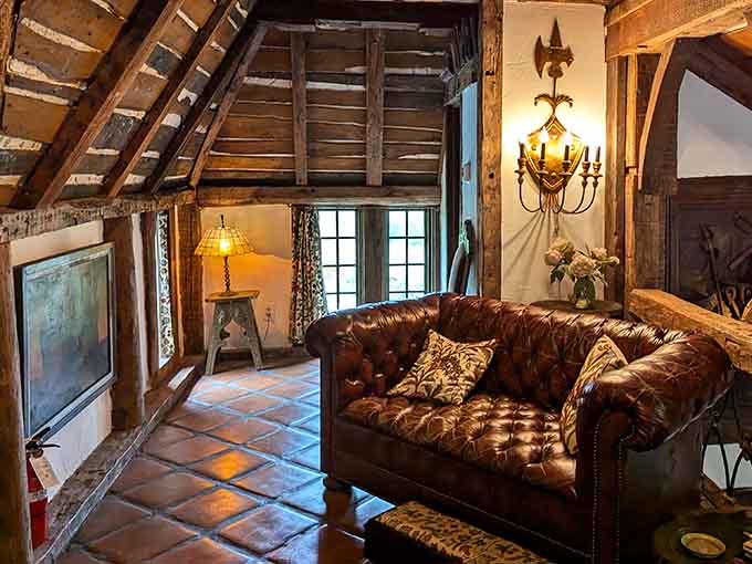 Exposed beams, leather furniture, and warm lighting create a space that's equal parts medieval fortress and cozy retreat.