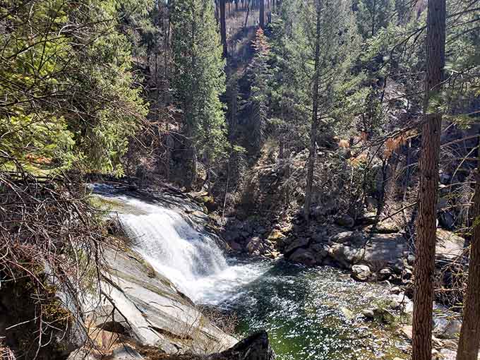 Sunlight catches the cascade as it tumbles through the forest, creating a private oasis worth every hiking step.