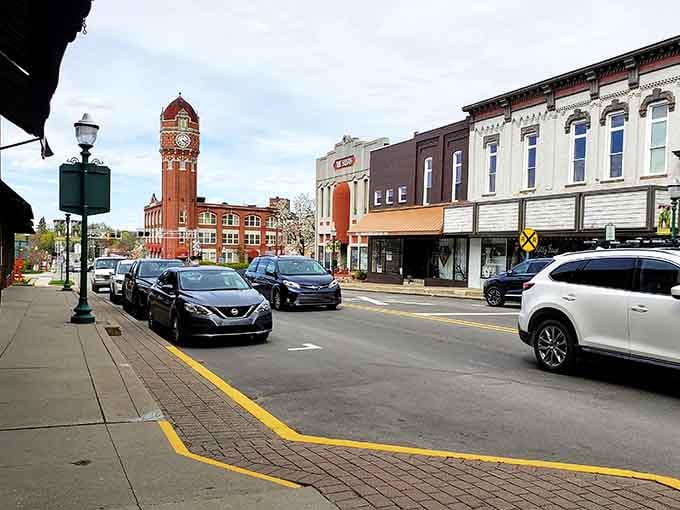 The distinctive clock tower anchors this main street where brick buildings stand proud through changing decades.