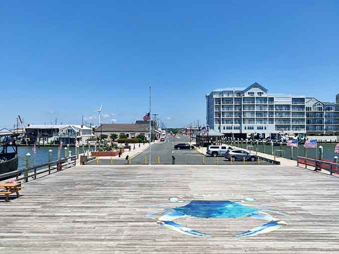 This boardwalk stretches toward the horizon with blue crab artwork underfoot, leading you straight into waterfront dining and maritime magic.