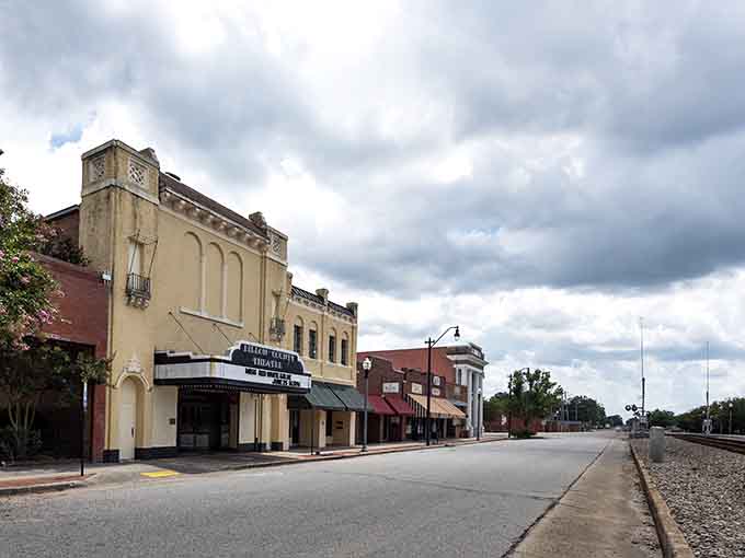 Classic theater facade under moody skies proving that small-town entertainment has character that multiplexes will never match.