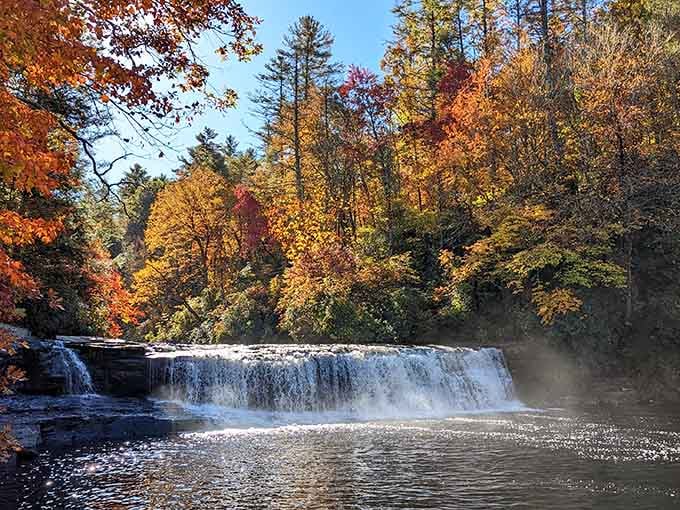 Fall's full glory surrounds this wide cascade, where mist rises from the pool and trees blaze in their finest colors.