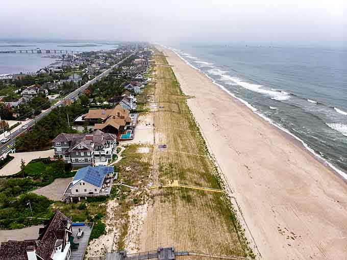 This aerial view reveals a barrier island paradise where pristine beaches meet charming homes in perfect coastal harmony.