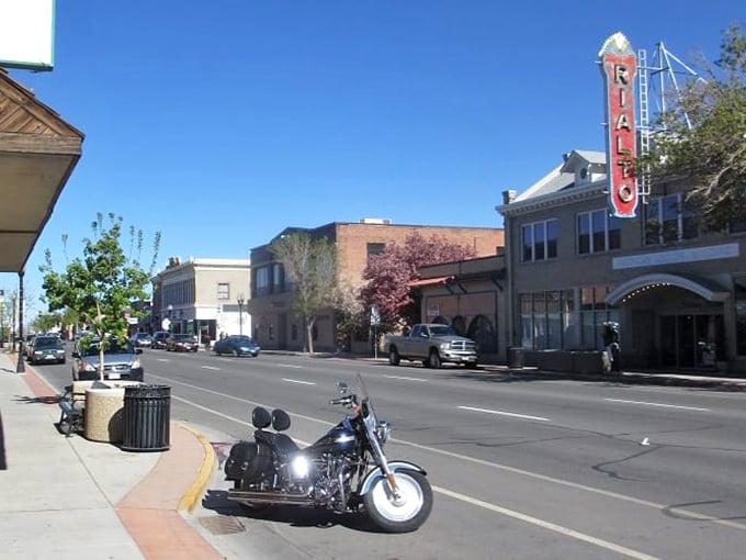 Alamosa welcomes you with sunny blue skies, a classic theater marquee, and a parked motorcycle perfect for a scenic cruise.