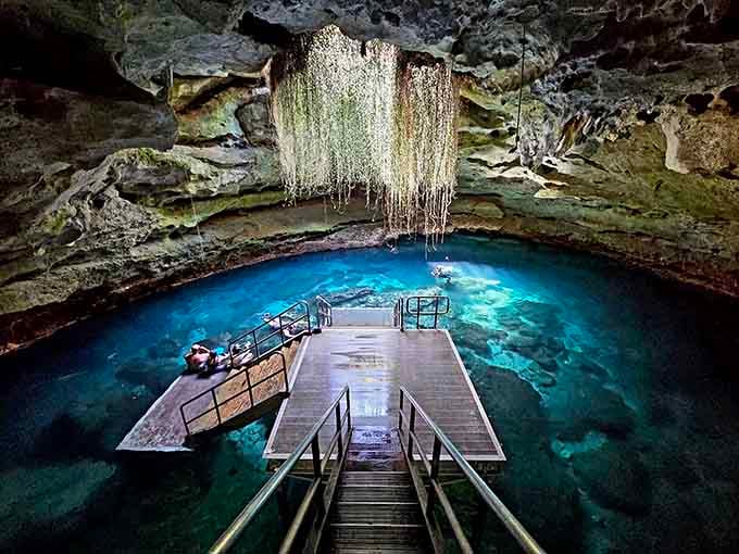 Sunlight pierces the cave opening, illuminating water so blue it seems lit from within by magic.