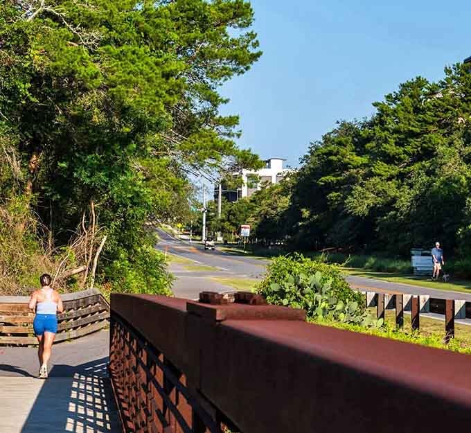 A jogger enjoys the wooden bridge path where exercise meets scenery in the most delightful way imaginable.