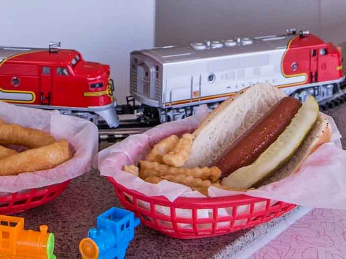 A grass-fed beef hot dog delivered by miniature train somehow tastes more authentic than any gourmet version.