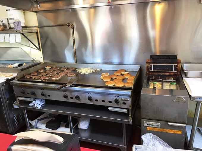 That gleaming flat-top griddle is where the magic happens, turning simple ingredients into roadside legends one patty at a time.
