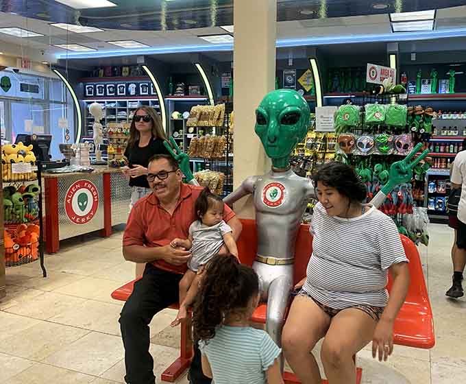 Families posing with aliens because some vacation photos just need that extra touch of intergalactic absurdity and joy.