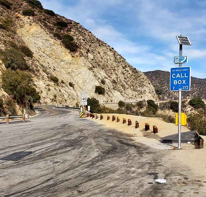 Emergency call boxes stand ready, solar-powered guardians watching over travelers in this remote mountain corridor.