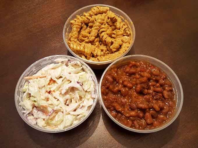 The holy trinity of barbecue sides: creamy coleslaw, rich beans, and cheesy pasta perfection in harmony.