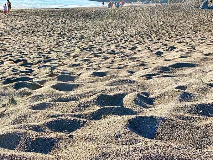 Those footprints in mixed sand show where volcanic black meets regular beach, like geological marble cake.