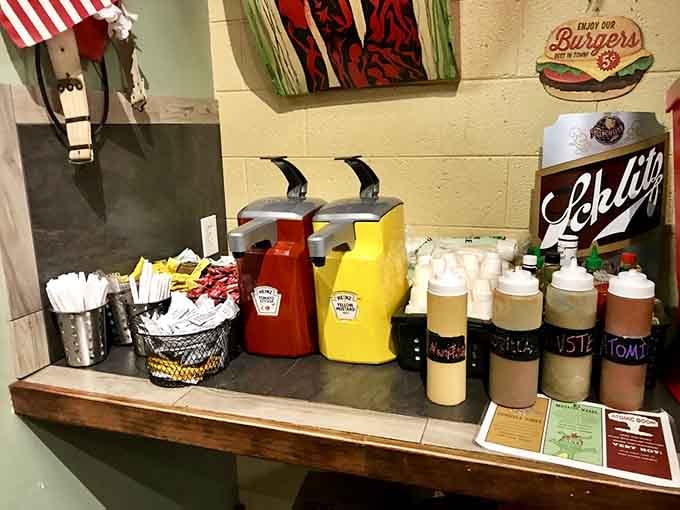 The condiment station with squeeze bottles and a vintage Schlitz sign: help yourself to burger perfection.