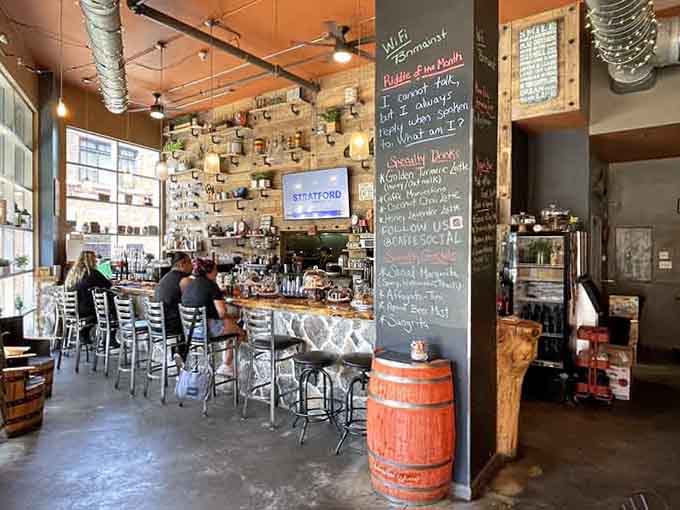 The bar area features reclaimed wood shelving displaying coffee treasures like a caffeinated museum of delicious possibilities and vintage charm.