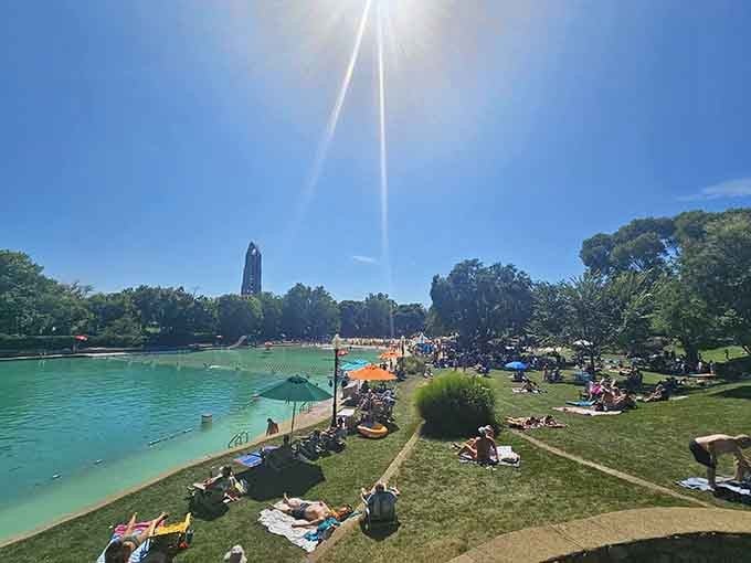 Blankets dot the grassy hillside where sunbathers perfect their tans while keeping one eye on the kids splashing below in crystalline water.
