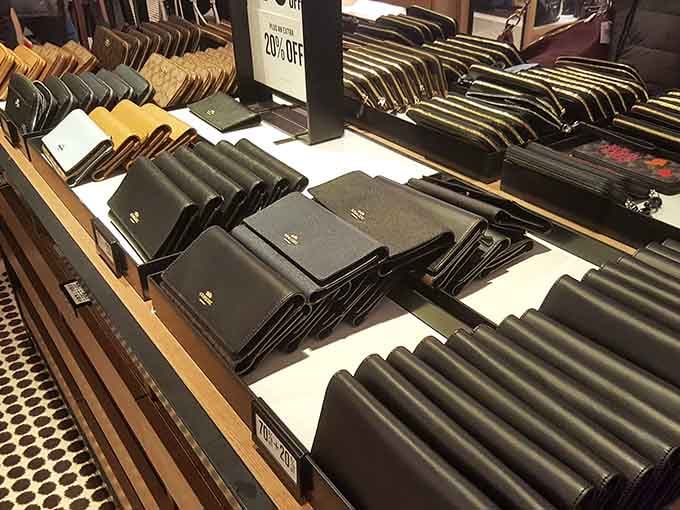 Wallets stacked like dominoes, each one promising better organization than the crumpled receipts currently in your pocket.