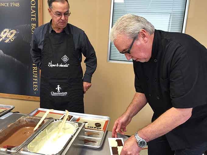 Master chocolatiers demonstrating their craft with the precision of surgeons and the passion of artists combined perfectly.
