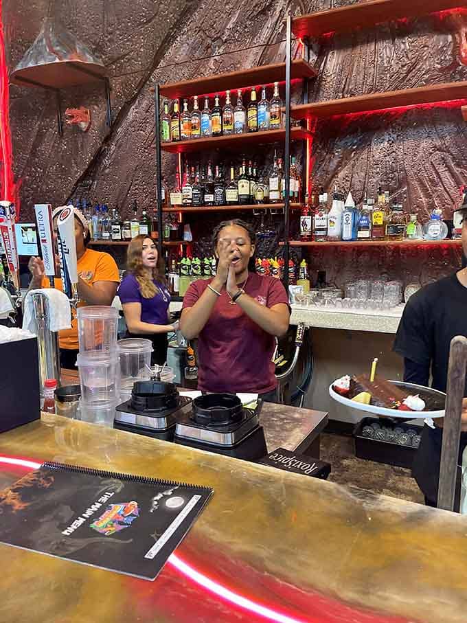 Friendly staff serving meals beneath a dragon, because why limit yourself to just one prehistoric era?