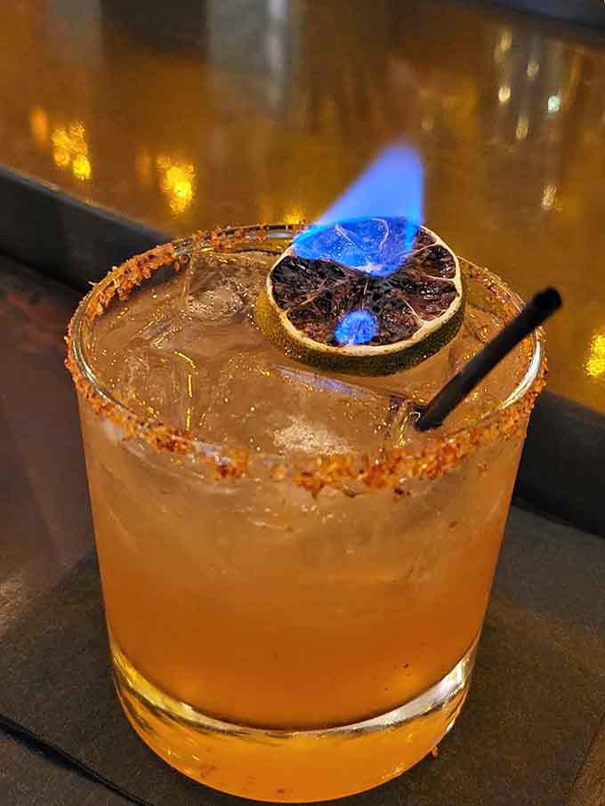A flaming citrus garnish adds theatrical flair to this cocktail, because sometimes your drink deserves its own spotlight moment.